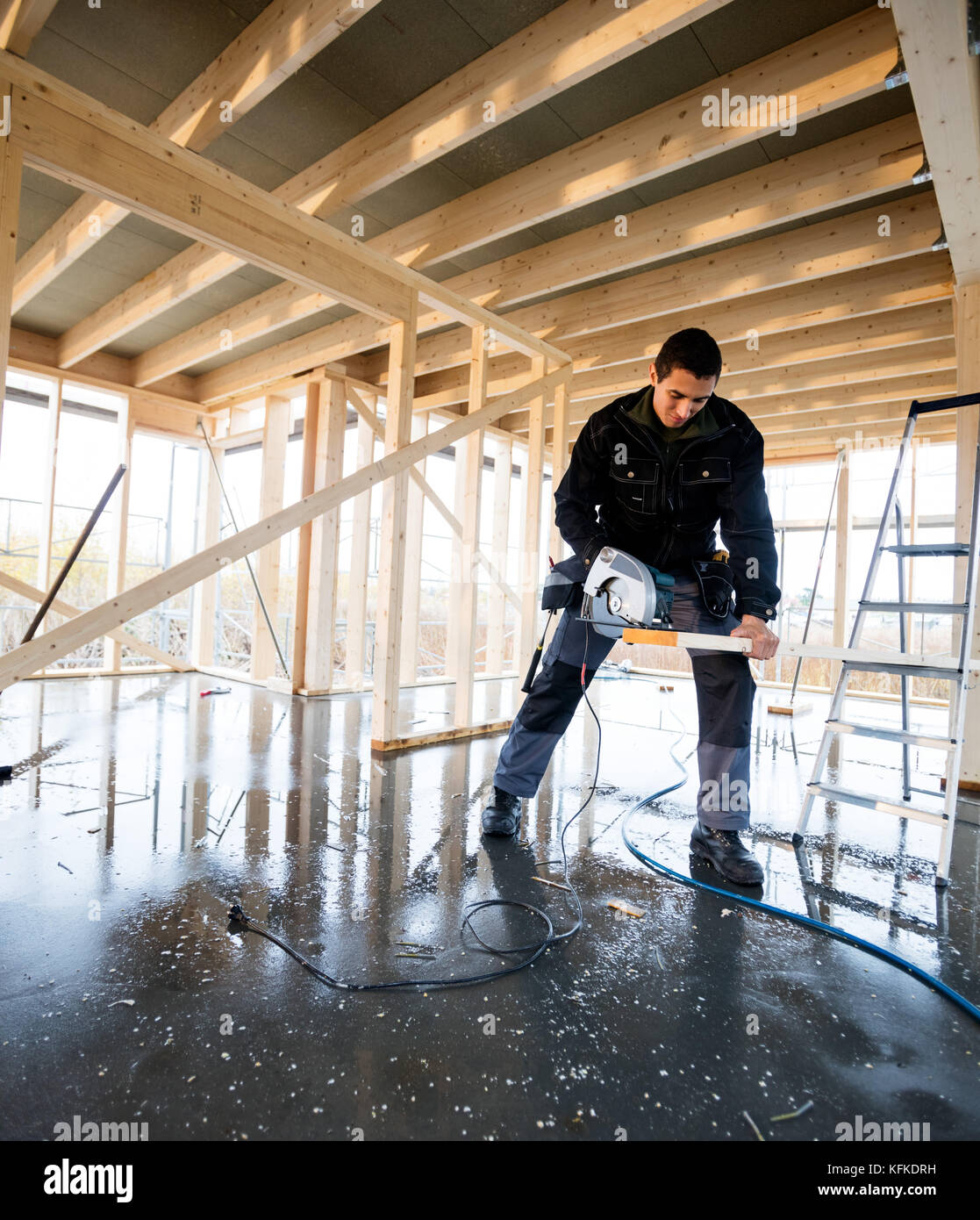 Carpenter Using Electric Hand Saw To Cut Wood At Site Stock Photo - Alamy