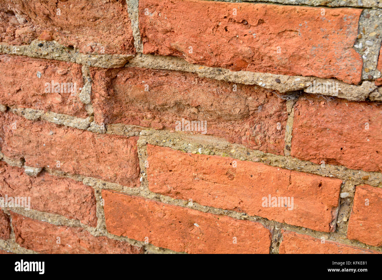 Brick wall in garden with bricks and mortar decaying diue to weathering ...