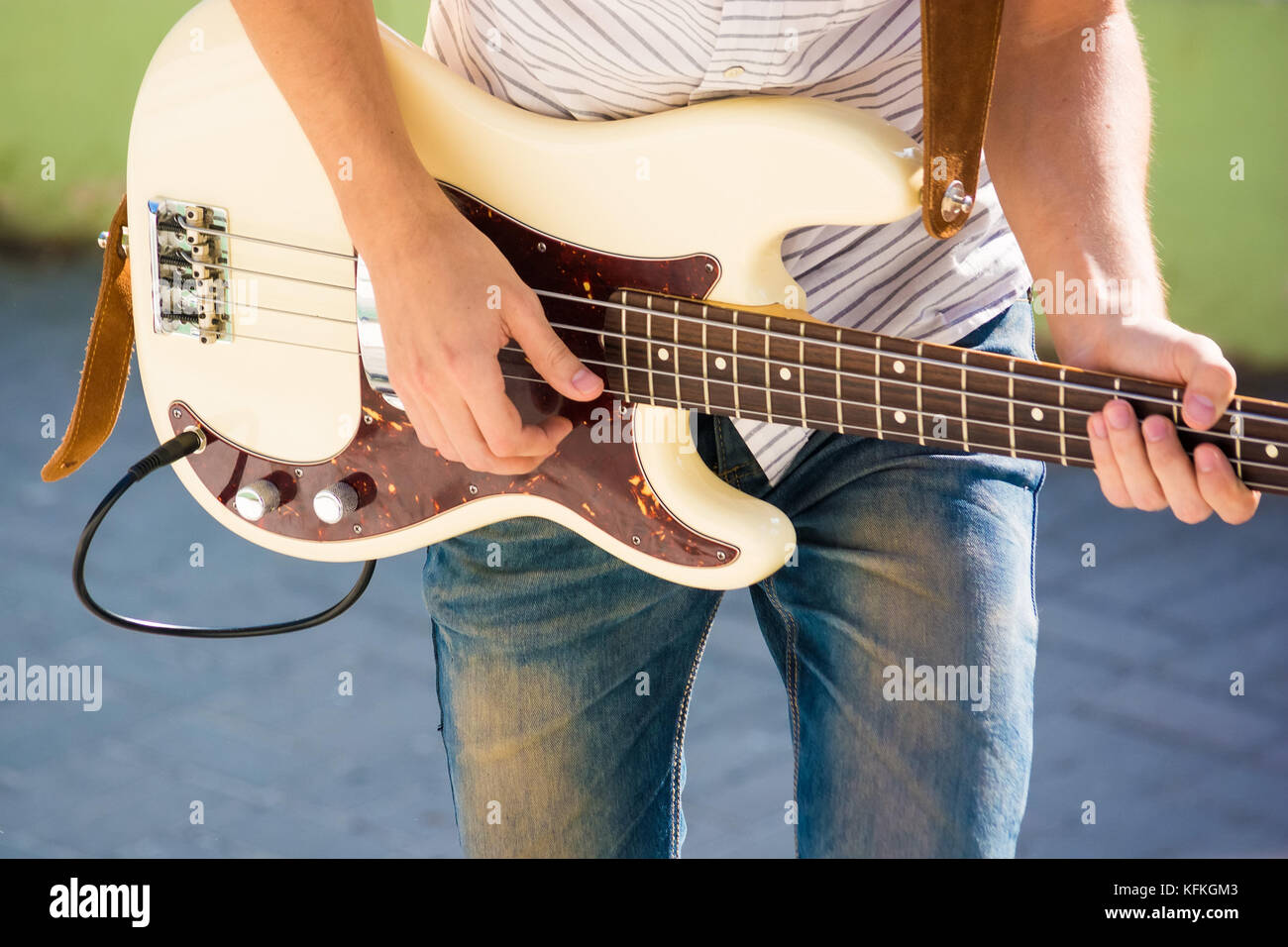 Close up of man playing bass guitar outdoors Stock Photo - Alamy