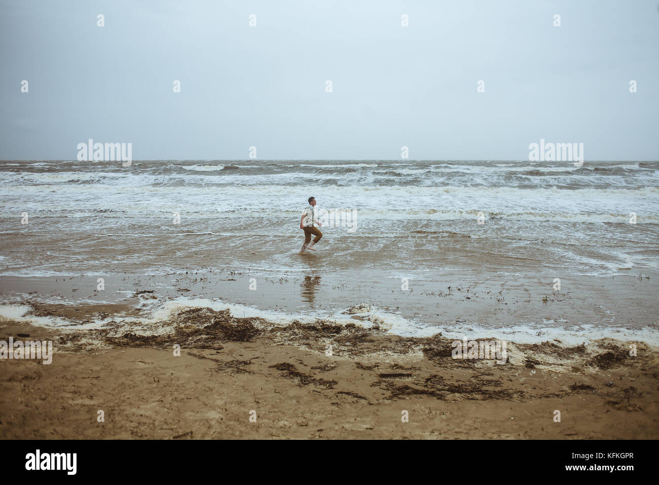 Man running along the seashore in stormy weather Stock Photo - Alamy