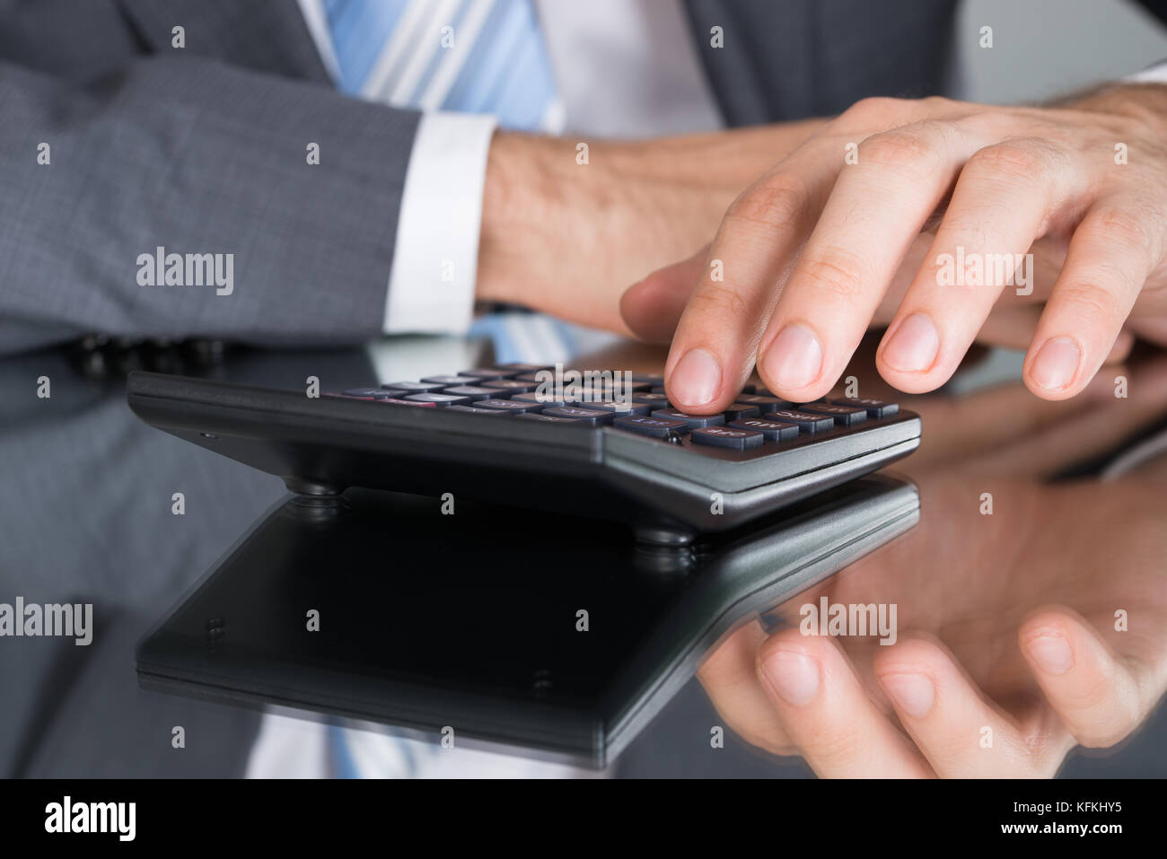 Accountant calculating tax using calculator at the table Stock Photo ...