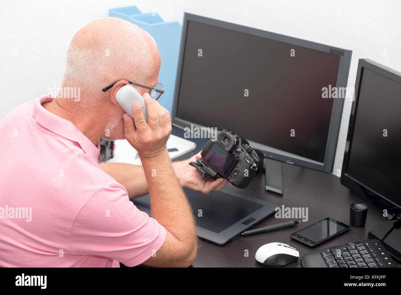 photographer with camera at office with computer, phone Stock Photo - Alamy
