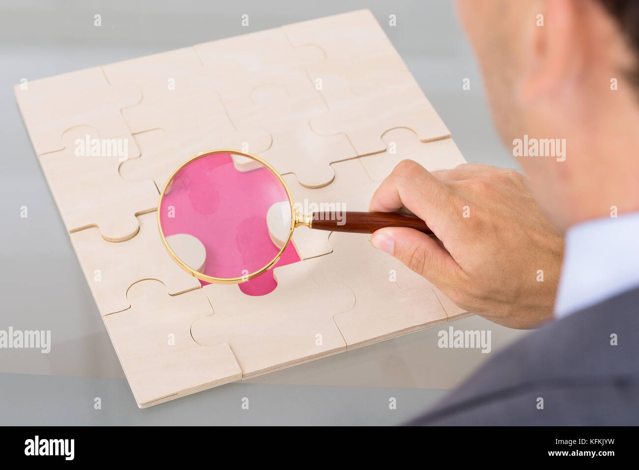 Businessman inspecting jigsaw puzzle. Over the shoulder view Stock ...