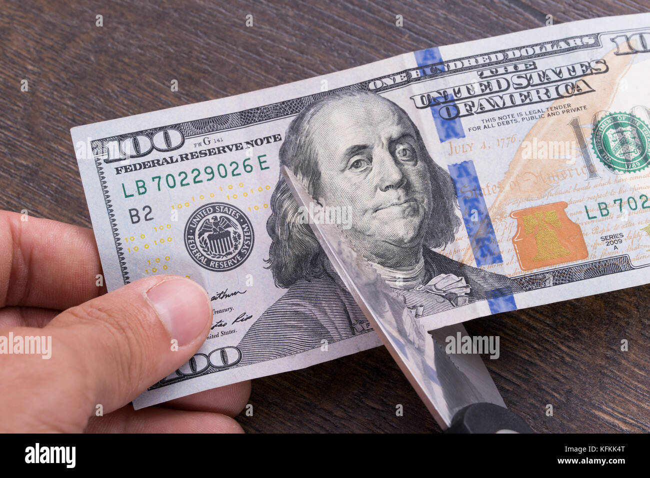 Cutting 100 dollar currency bill using scissors Stock Photo - Alamy