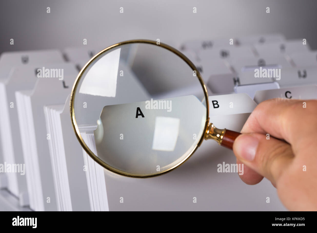 Investigating documents with magnifying glass over black background ...