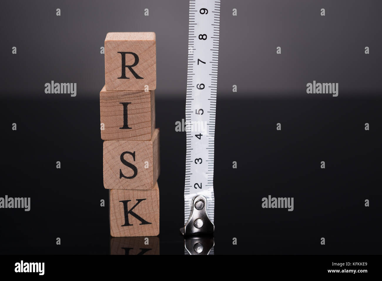 Measuring risks with ruler over black background Stock Photo - Alamy