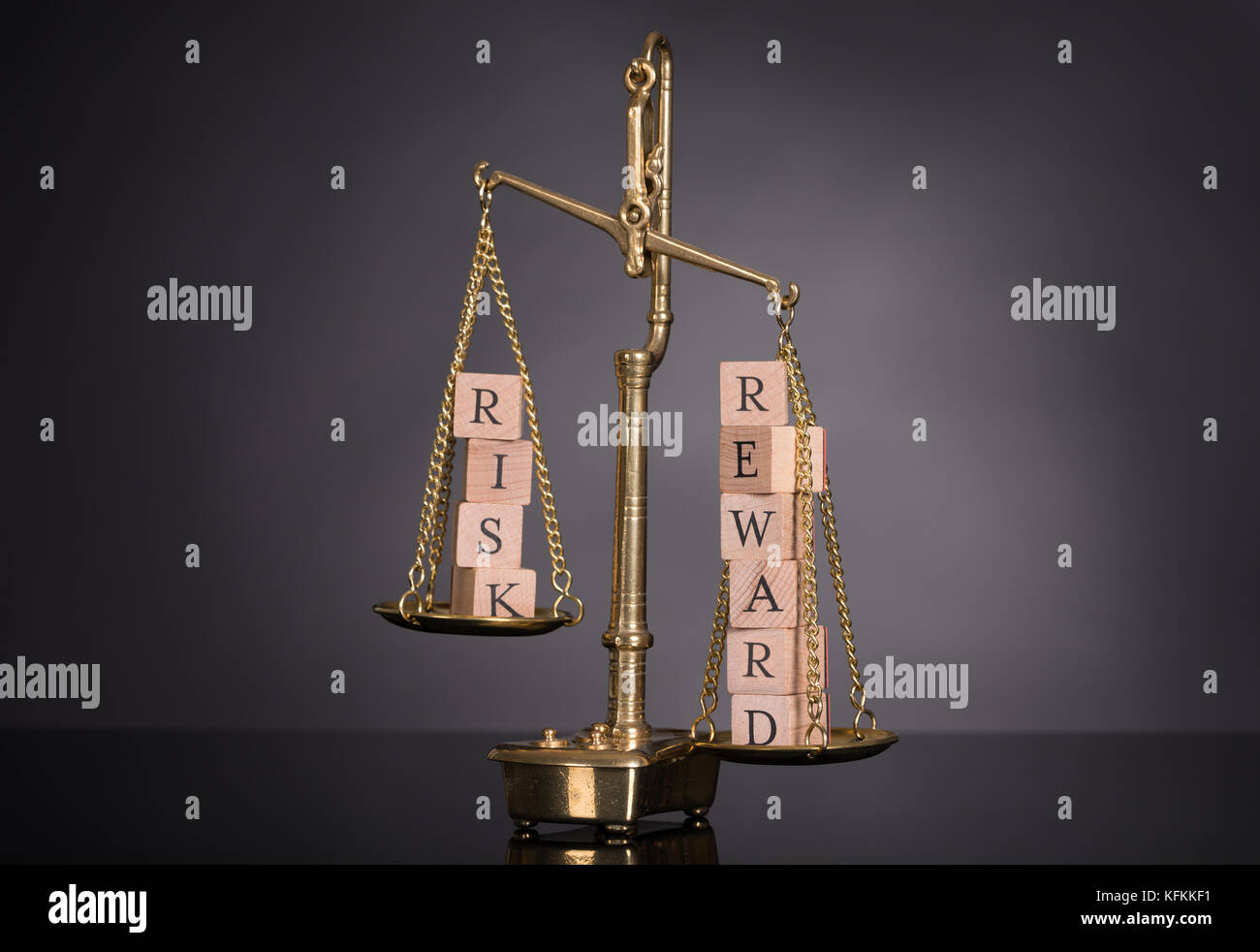 Weighting risk and rewards over black background Stock Photo - Alamy
