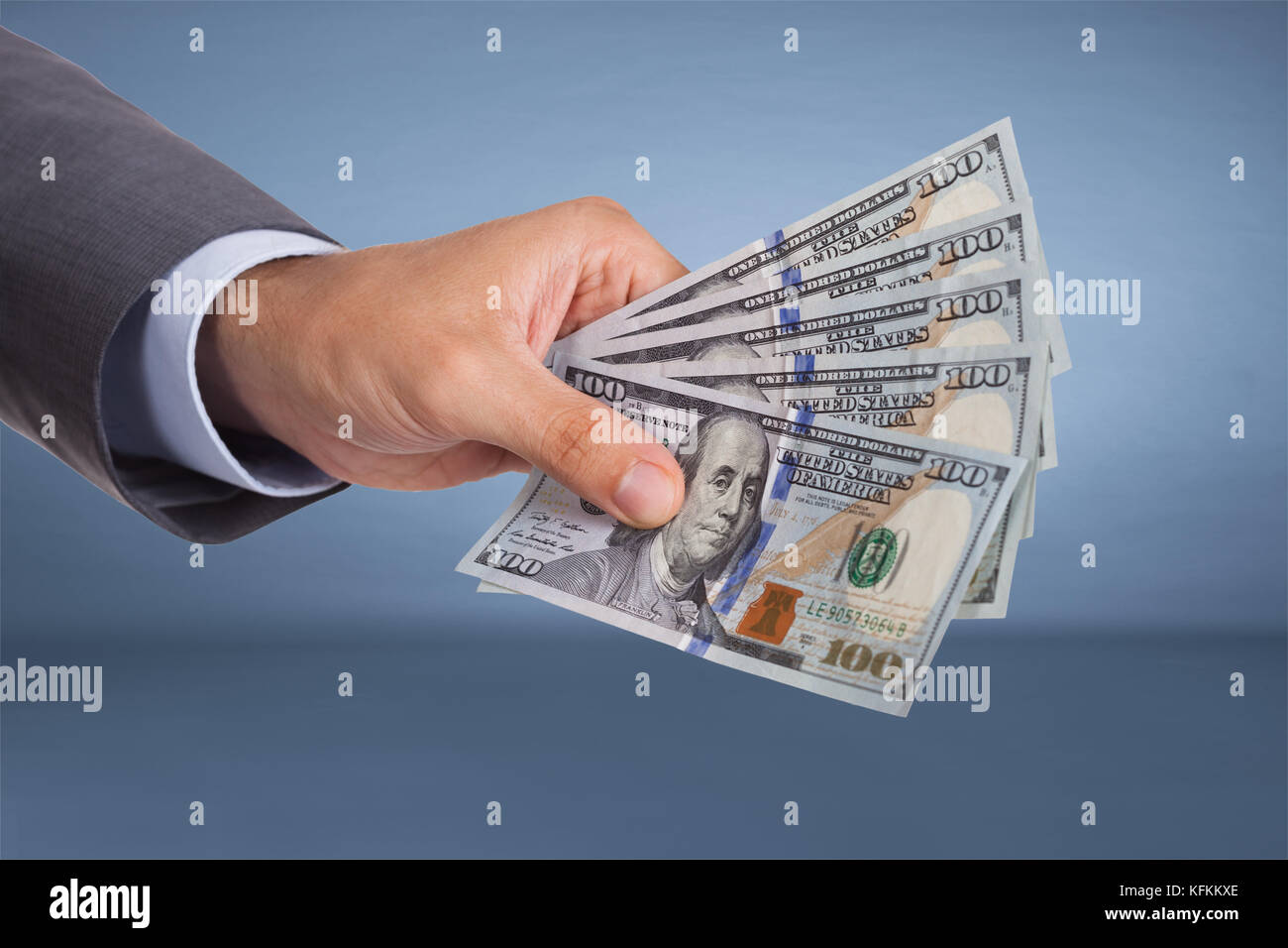Hand holding paper currency over blue background Stock Photo - Alamy