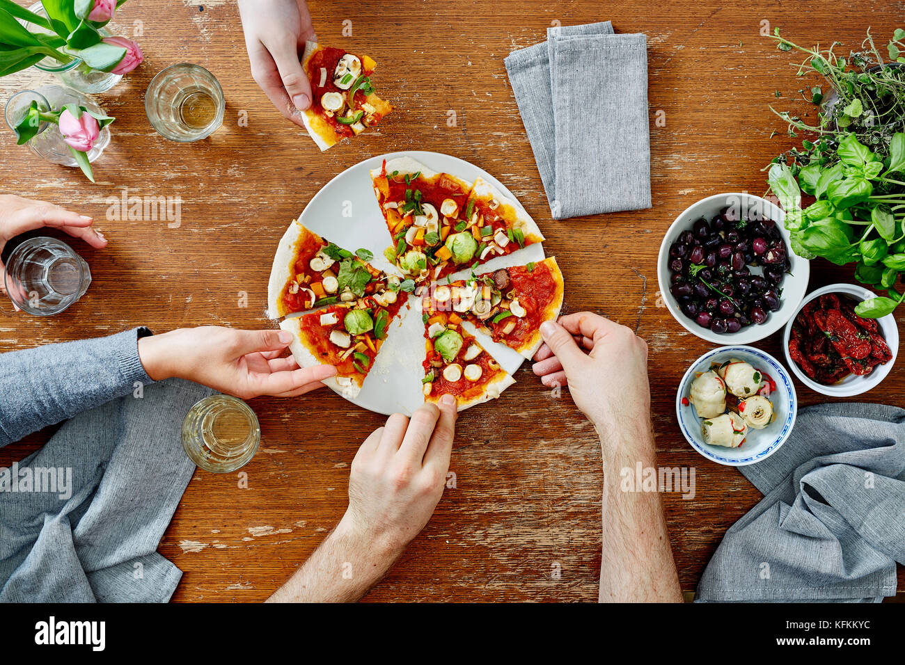 three people sharing organic delicious pizza at dinner party Stock ...