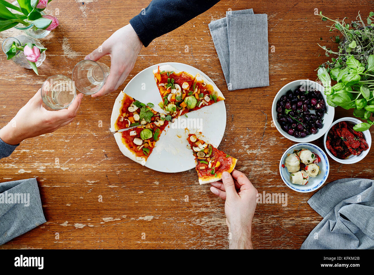 two people toasting with wine one person eating pizza Stock Photo - Alamy