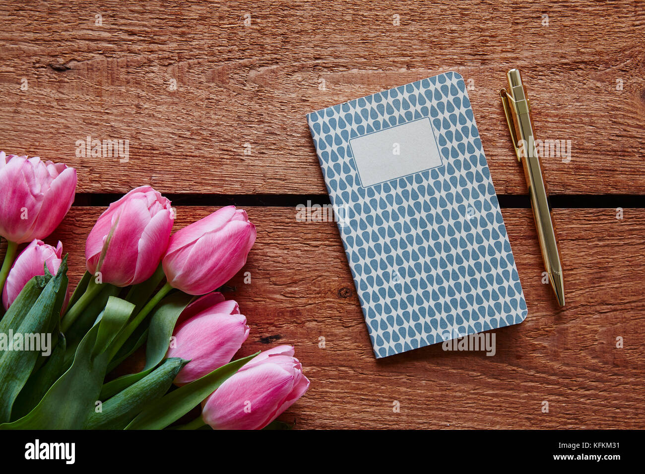 a bunch of pink tulips writing in a notebook spring atmosphere Stock ...
