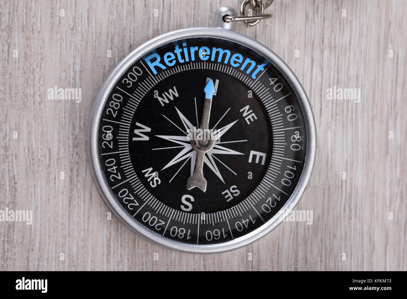 Closeup of compass on wooden table indicating Retirement word Stock ...