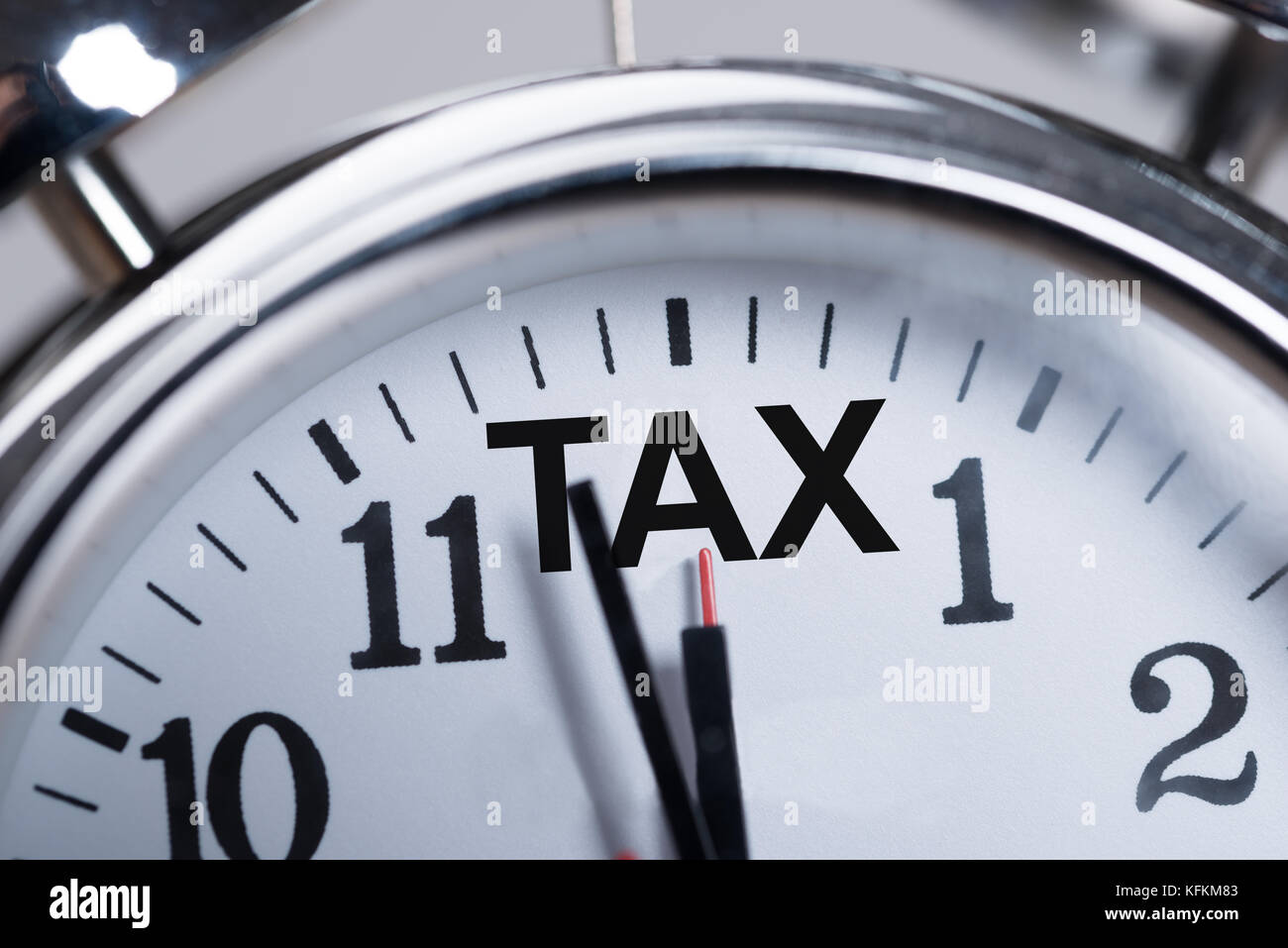 Cropped image of alarmclock showing arrival of tax time Stock Photo - Alamy