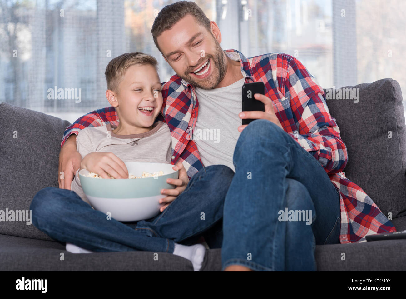 father and son watching tv Stock Photo - Alamy