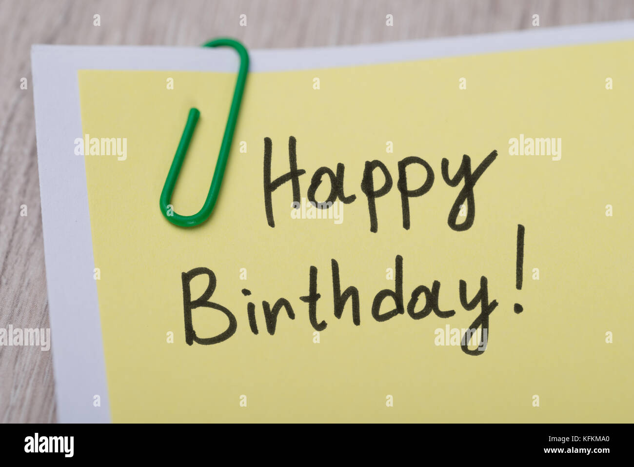 Closeup of Happy Birthday ! written on yellow paper note with paperclip ...