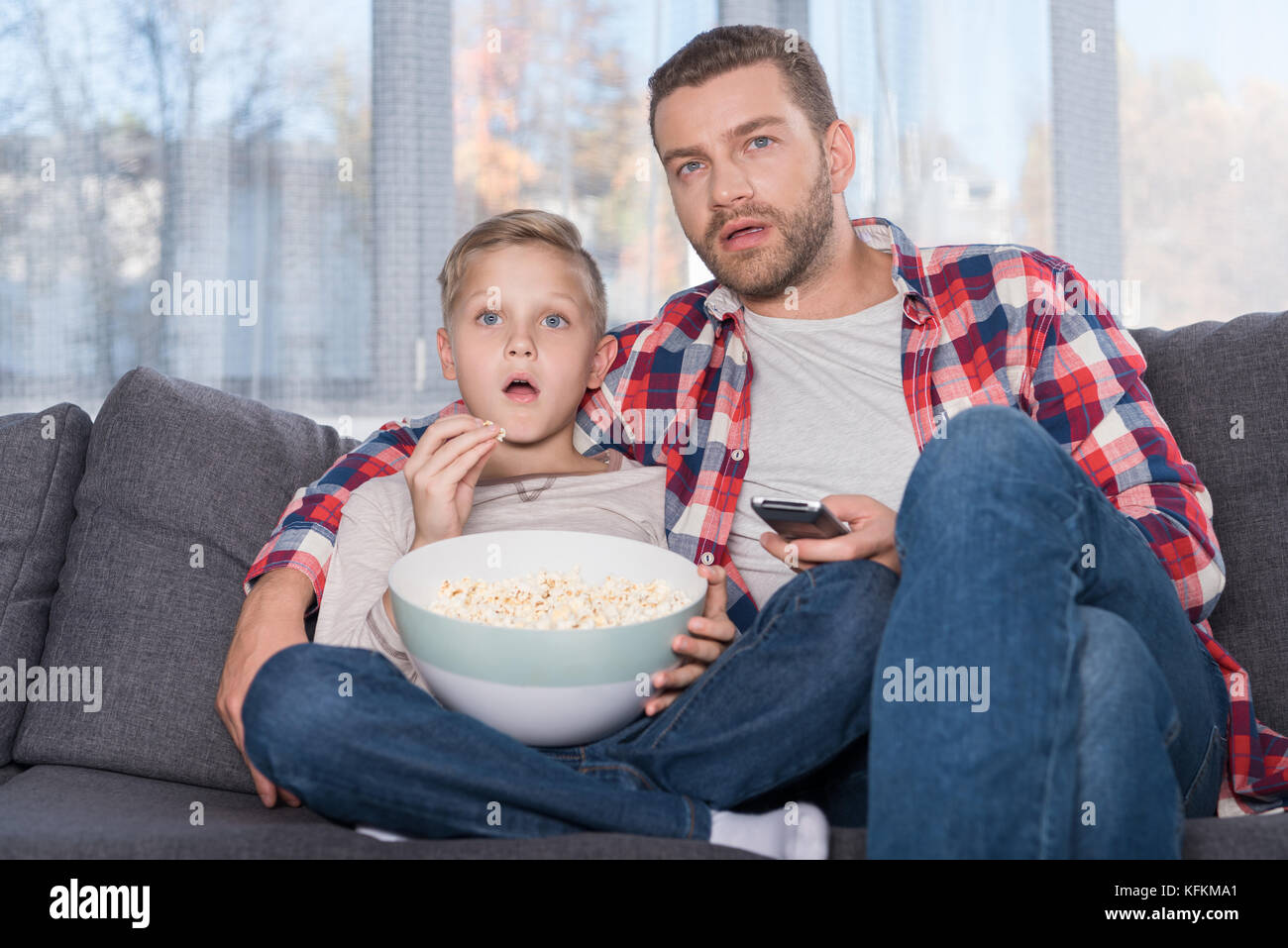 father and son watching tv Stock Photo - Alamy