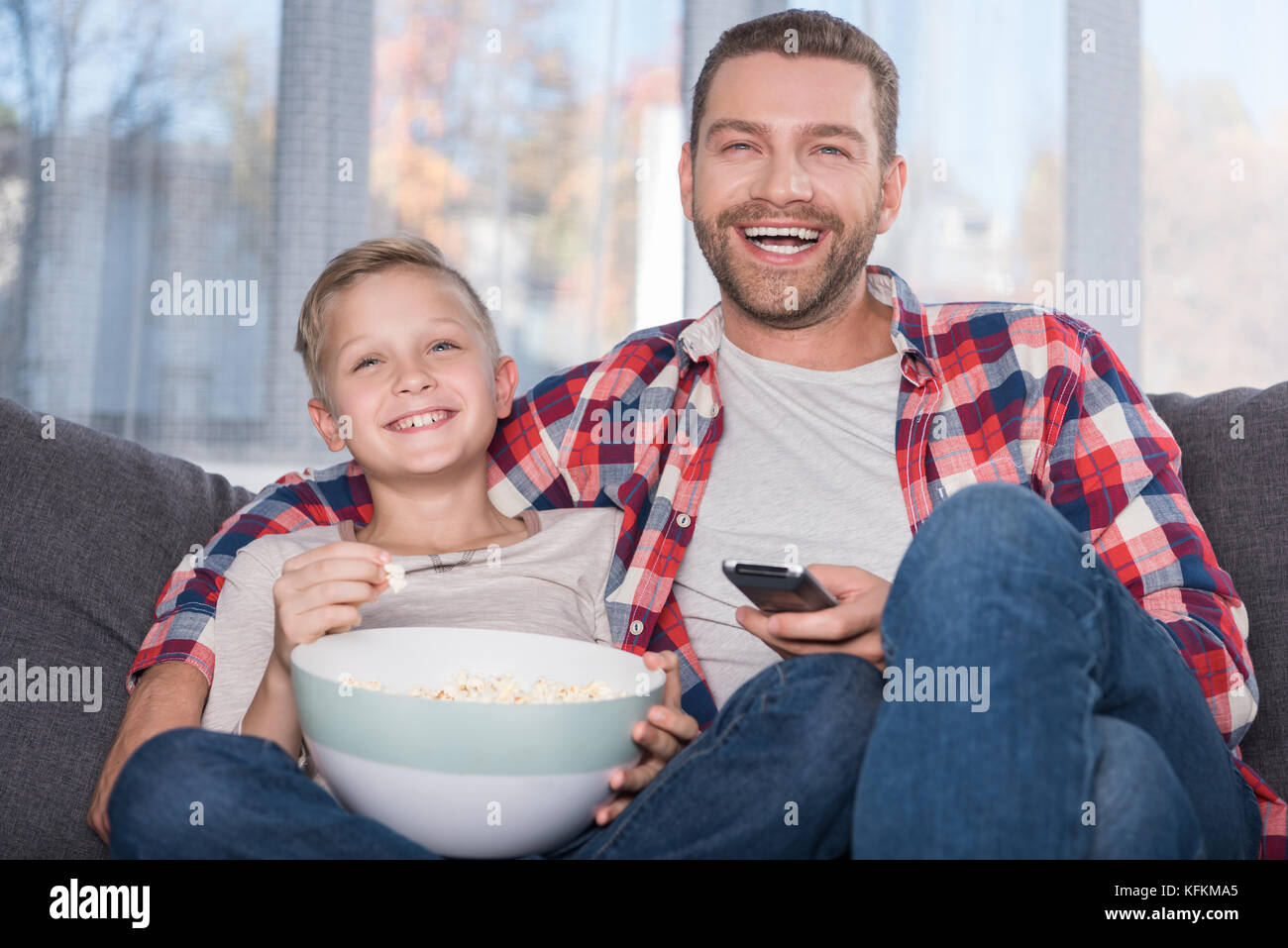 father and son watching tv Stock Photo - Alamy