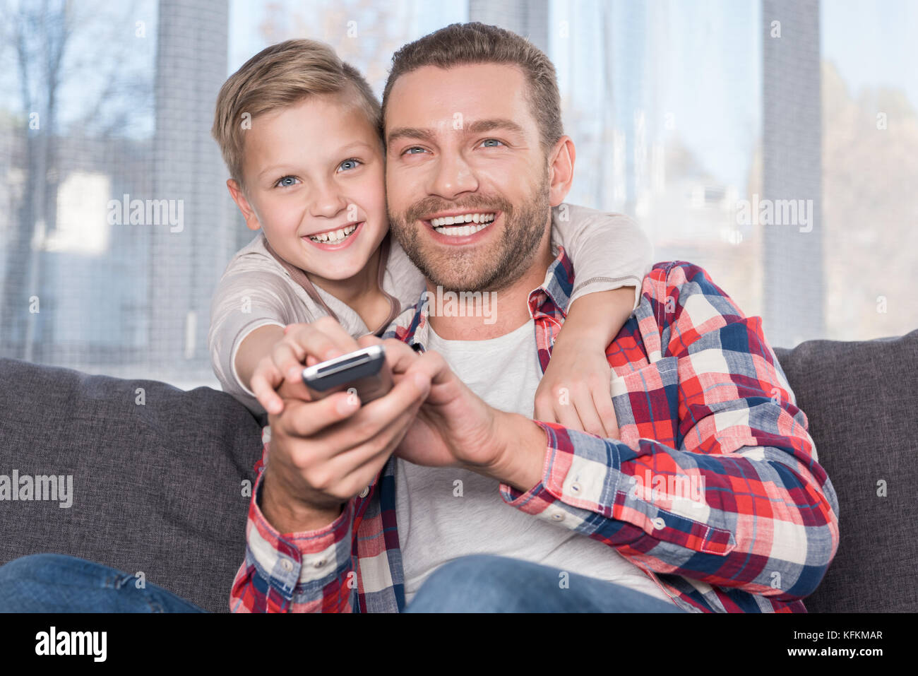 father and son watching tv Stock Photo - Alamy