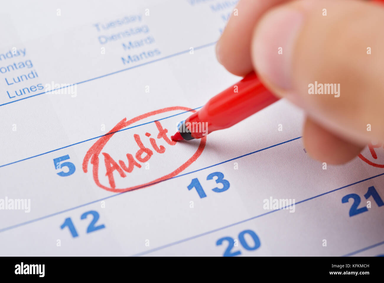 Cropped image of hand marking Audit date on calendar Stock Photo - Alamy