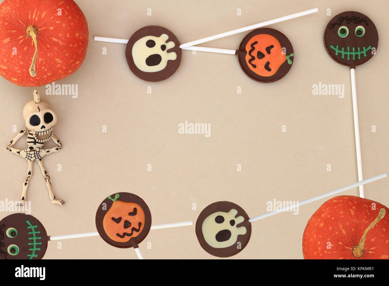 Halloween. Frame with chocolate lollipops, pumpkins and a funny ...