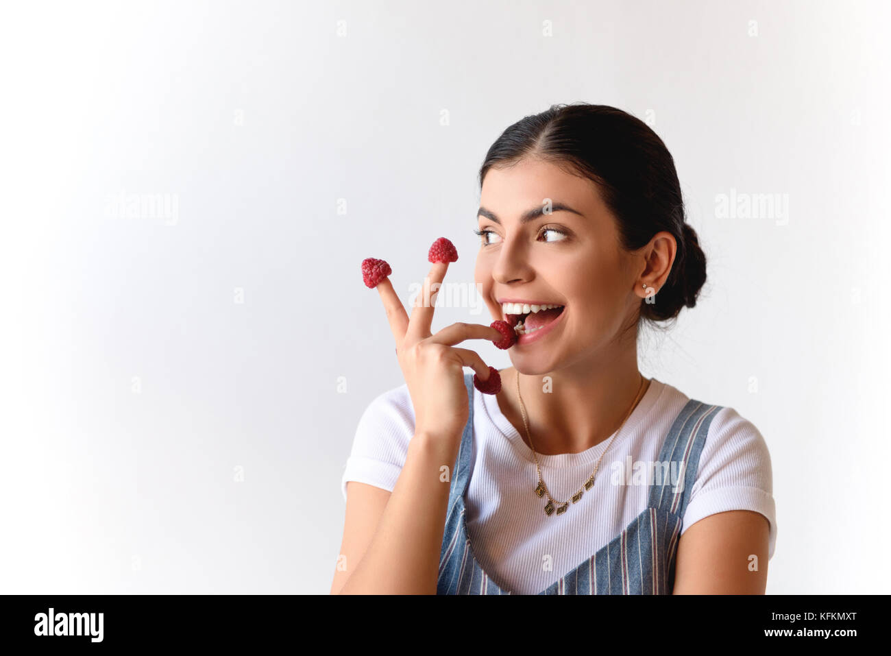 woman with raspberries on fingers Stock Photo - Alamy
