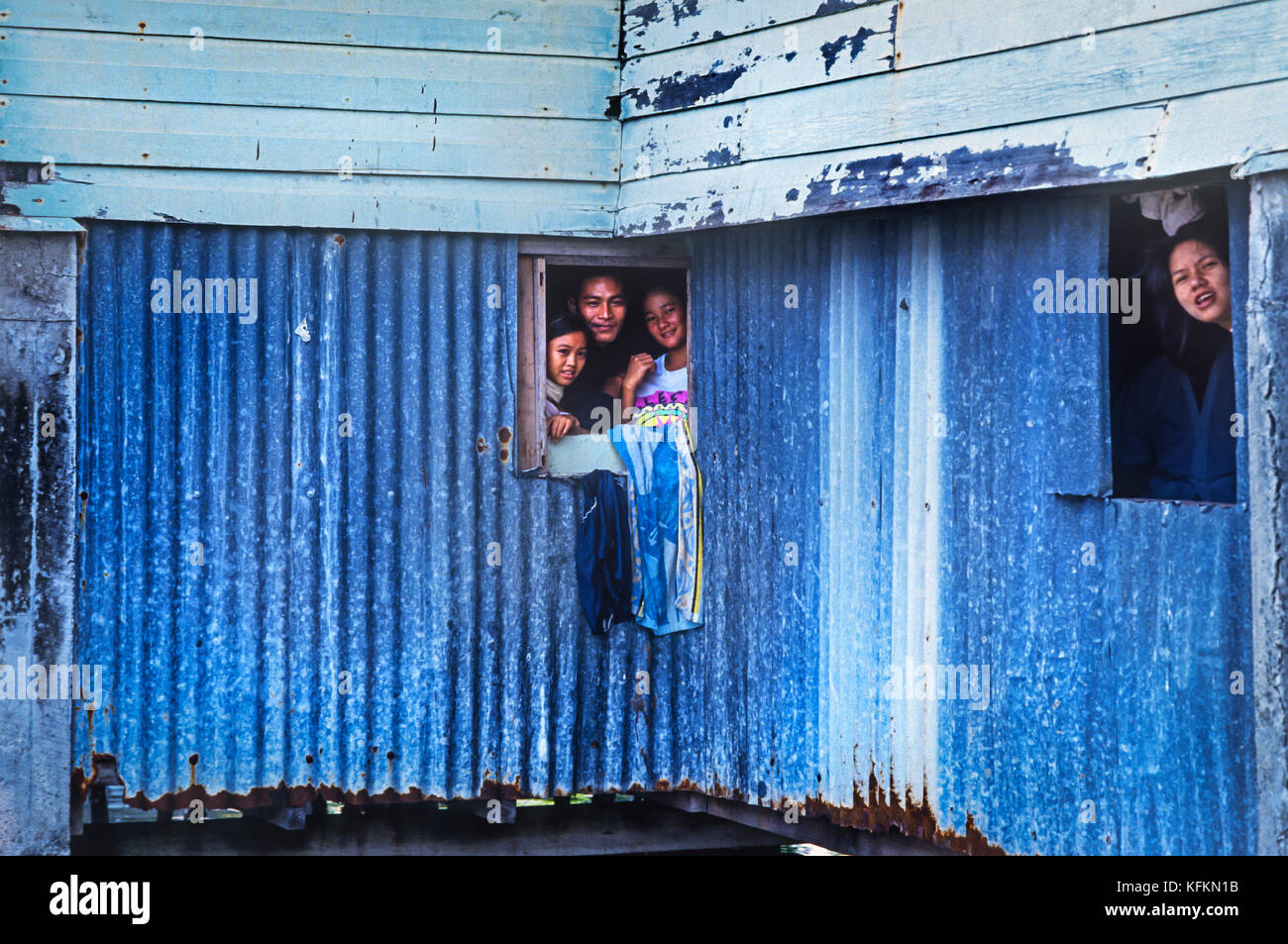 Family peering through window. Shanty town Borneo Malaysia, SE Asia ...