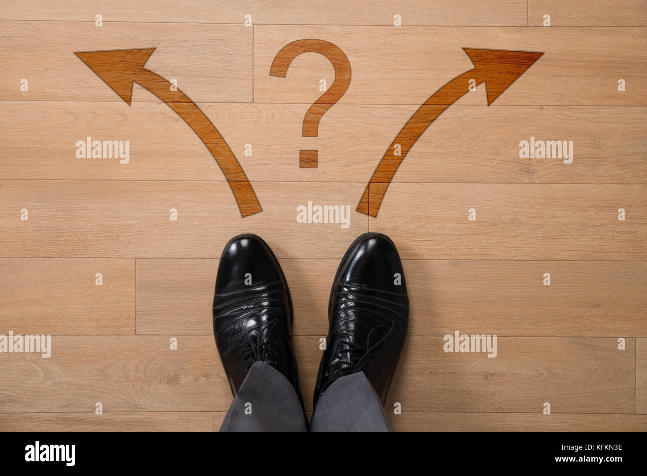 Low section of businessman standing in front of left or right arrows ...