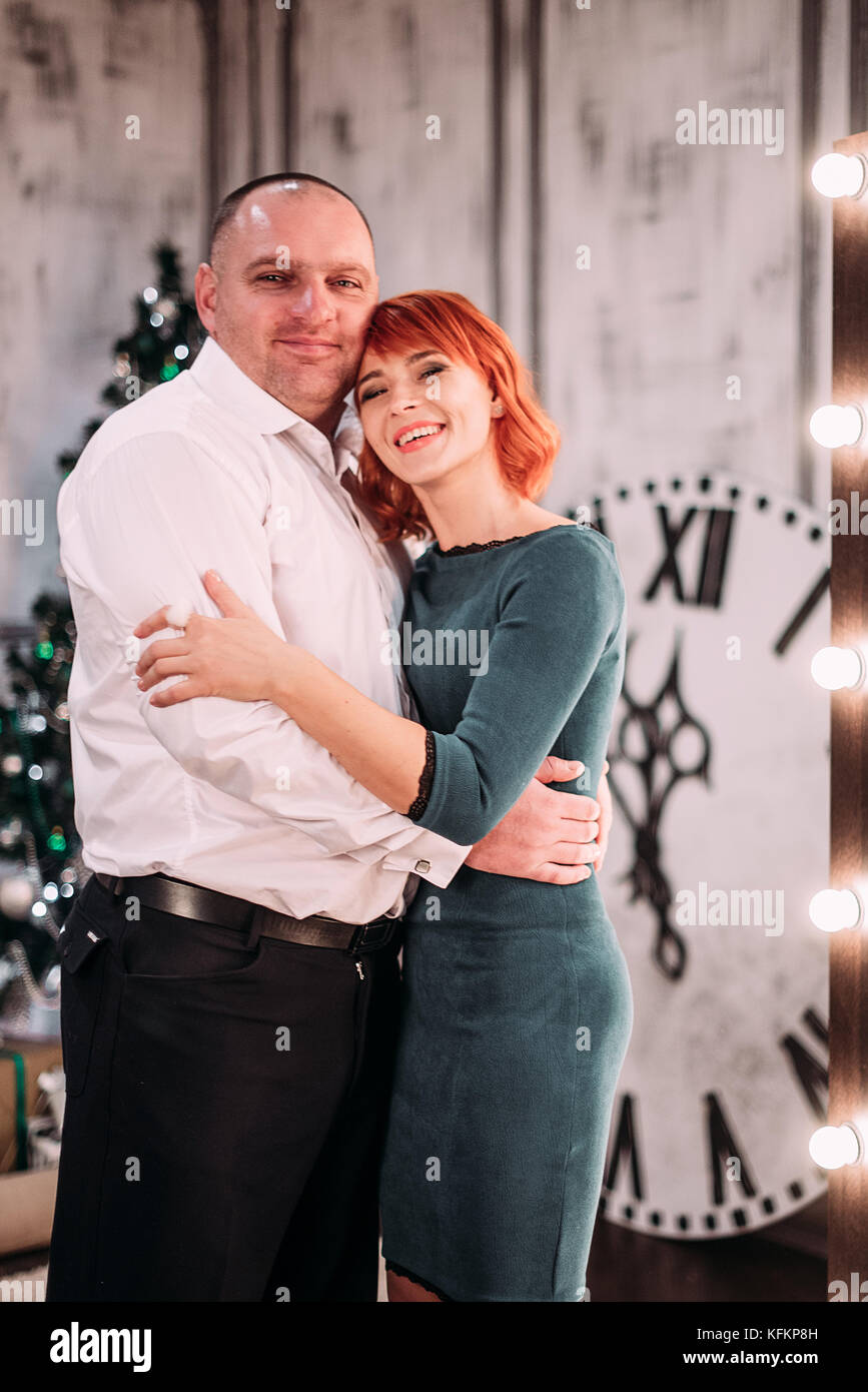 Happy adult couple hugging near Christmas tree Stock Photo - Alamy