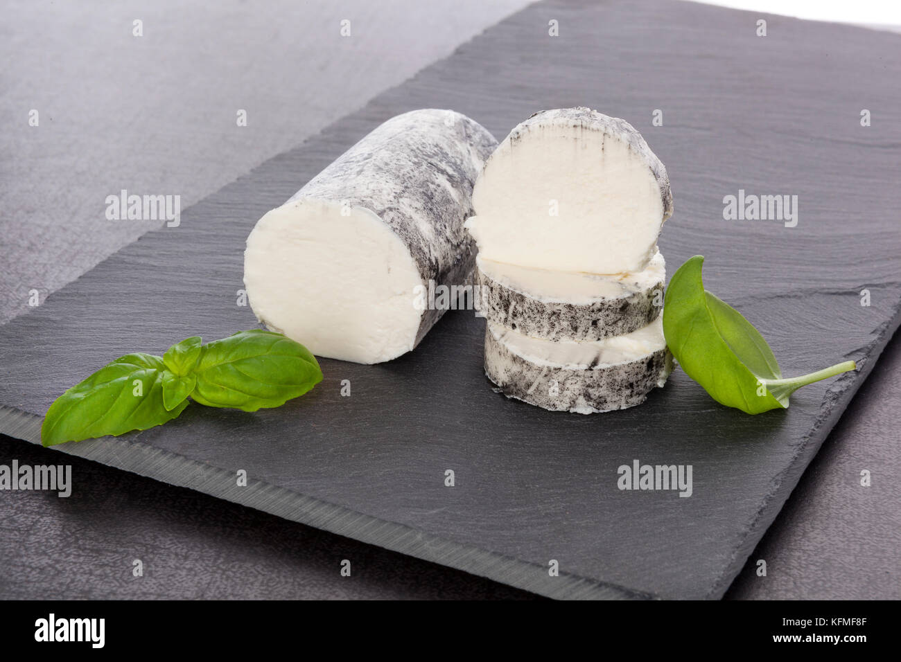 Goat cheese with basil on the minimalistic plate. Luxurious cheese ...