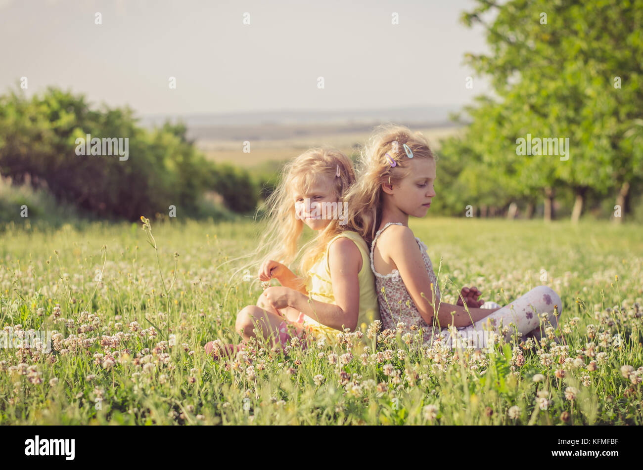 friends in the spring meadow sitting together Stock Photo - Alamy