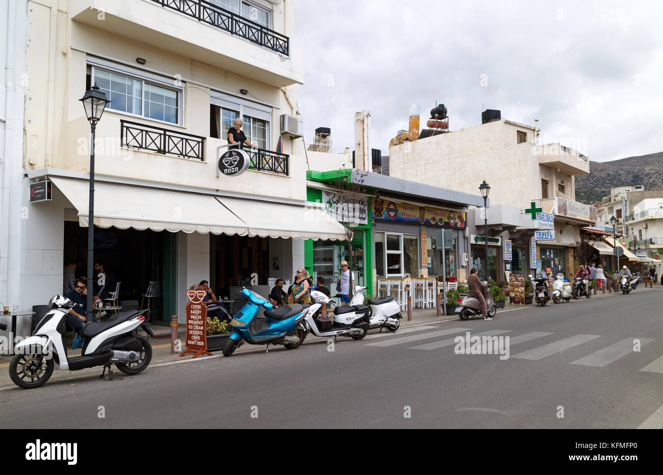 Malia, Crete, Greece. Scooters parked outside shops along the main ...