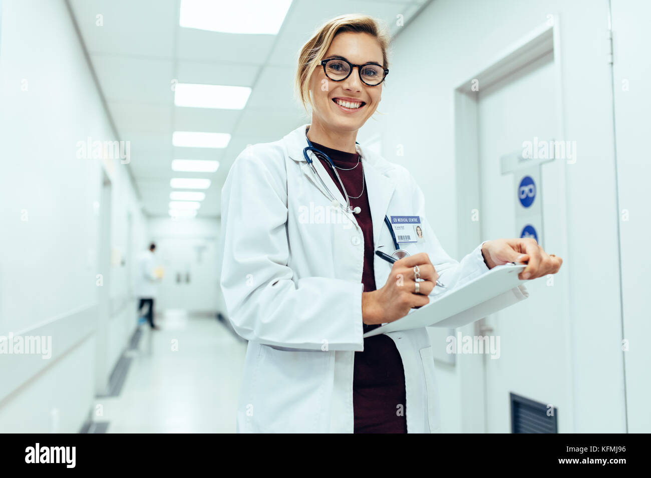 Portrait of female healthcare worker in hospital hallway with medical ...