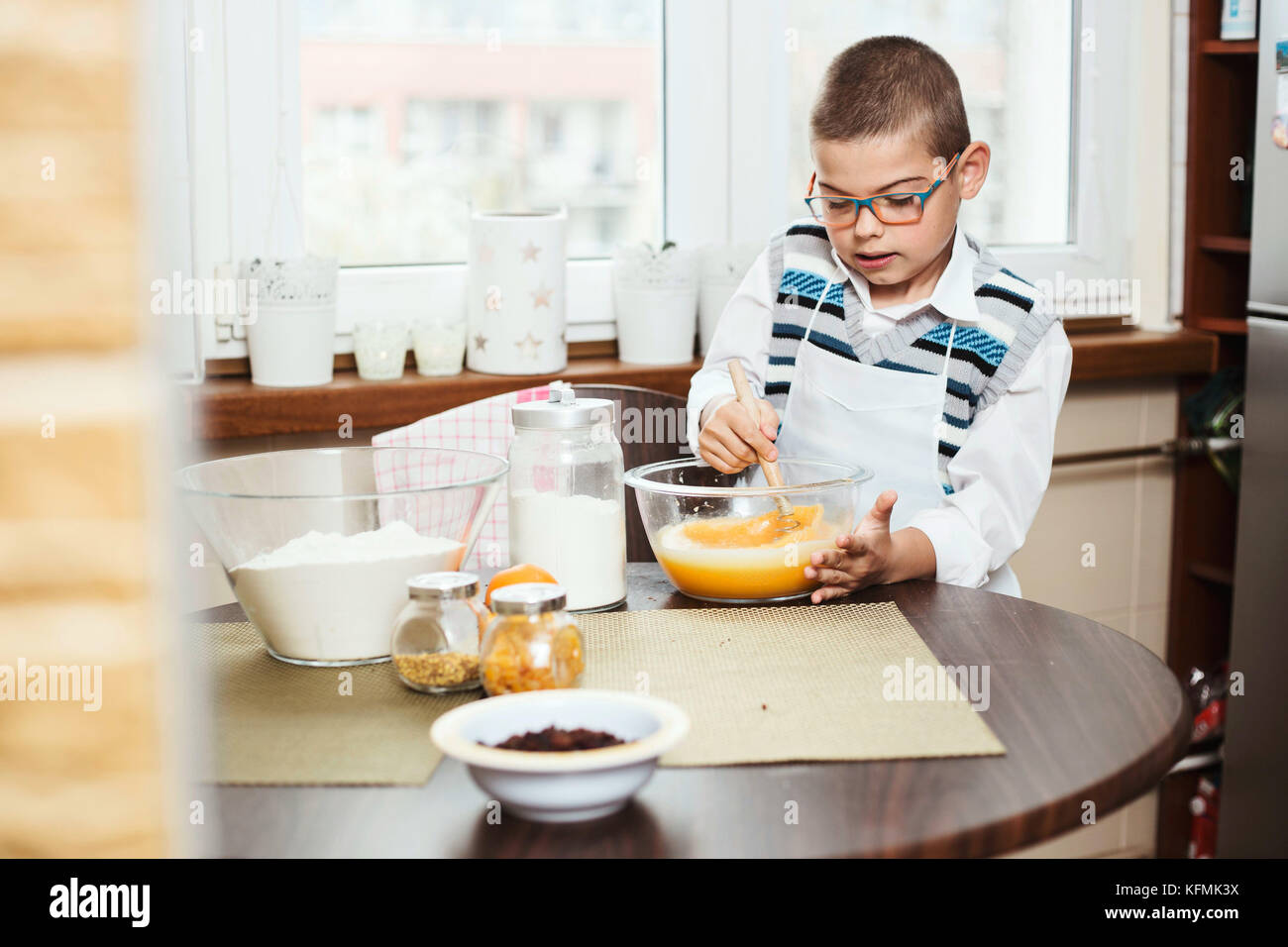 7-year-old boy mixing ingredients for baking a cake. Lifestyle image of ...