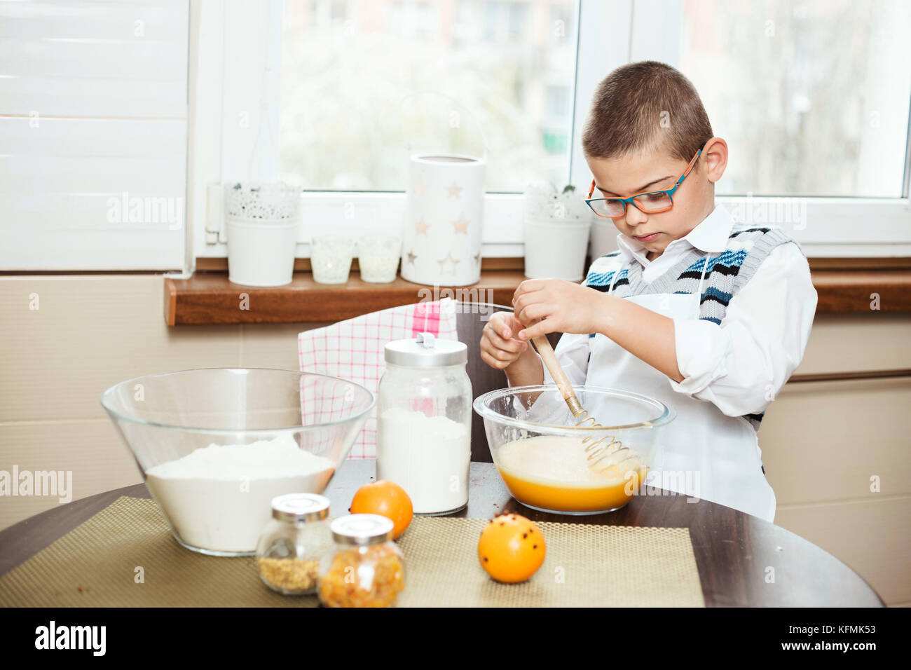 7-year-old boy mixing ingredients for baking a cake. Lifestyle image of ...