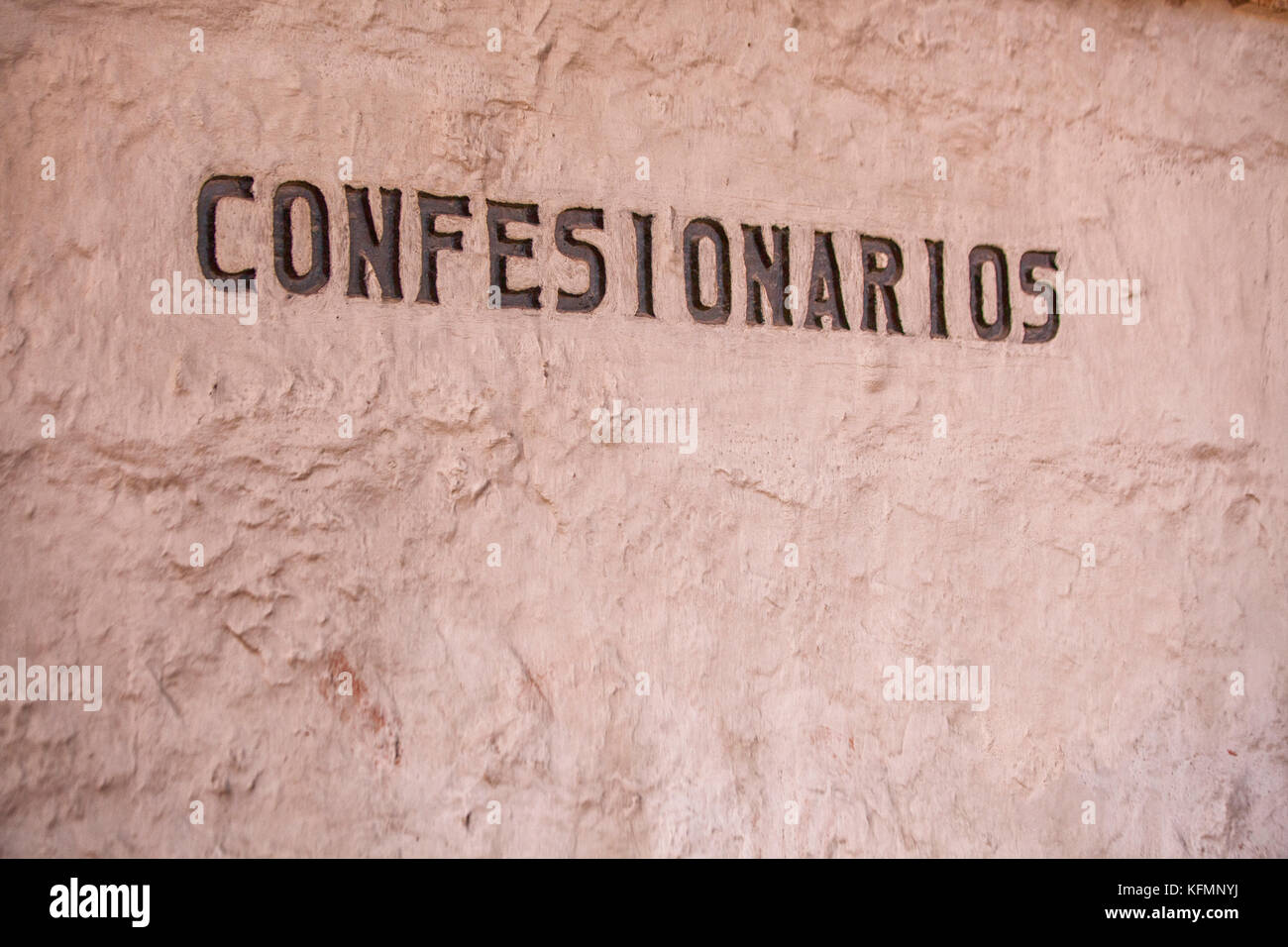 Confessionarios text carved in old pink wall in Peru. Confessionarios ...
