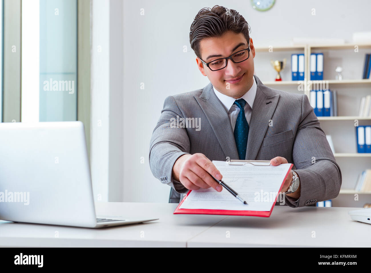 Businessman signing business documents in office Stock Photo - Alamy