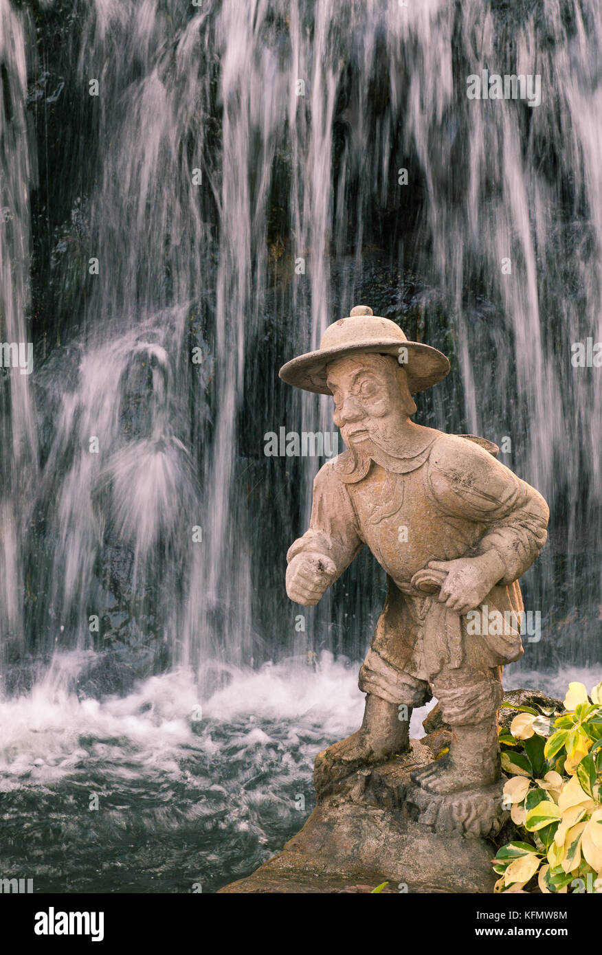 Stone sculpture in-front of waterfall Stock Photo - Alamy