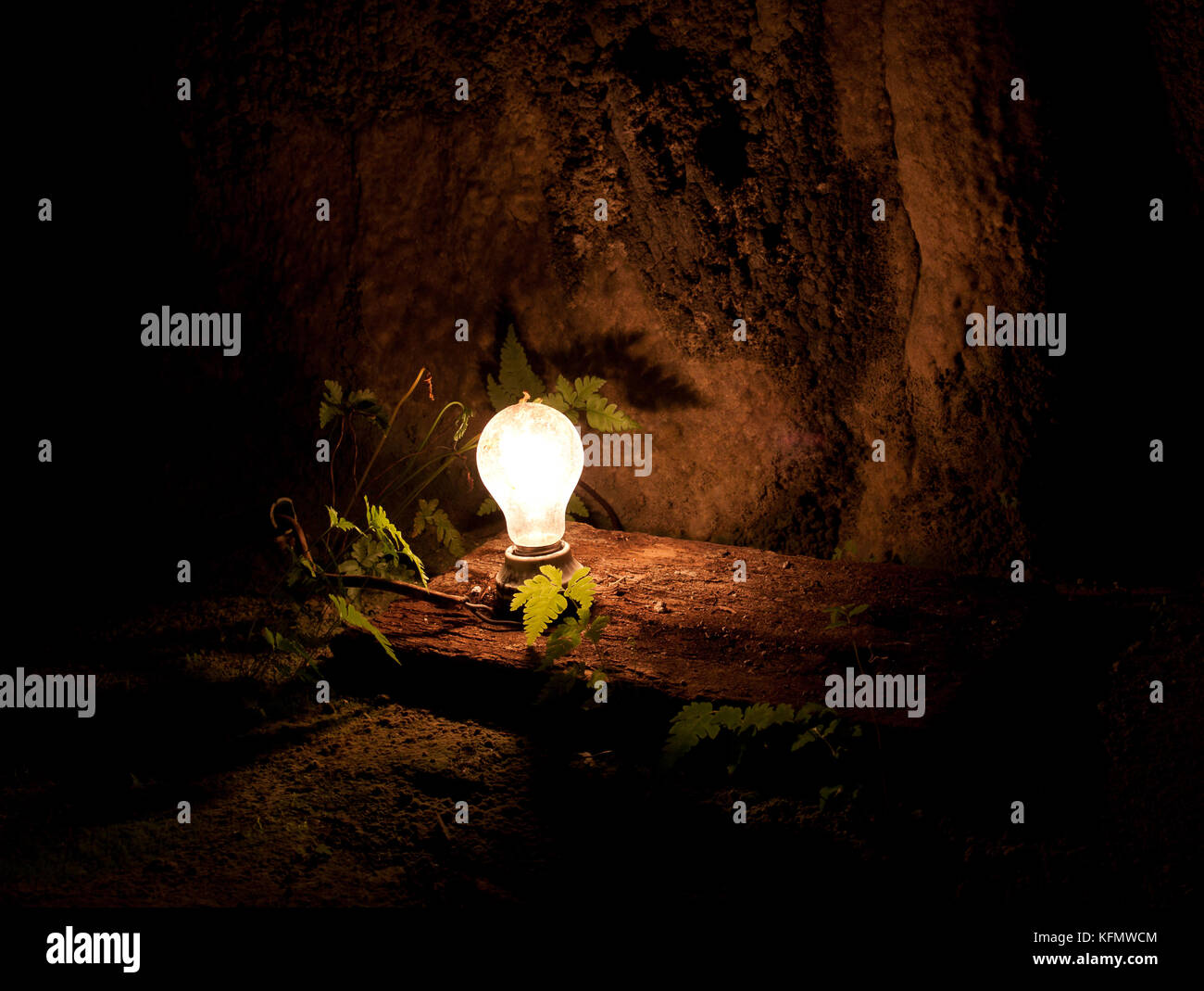 Lightbulb illuminates interior of a cave Stock Photo - Alamy