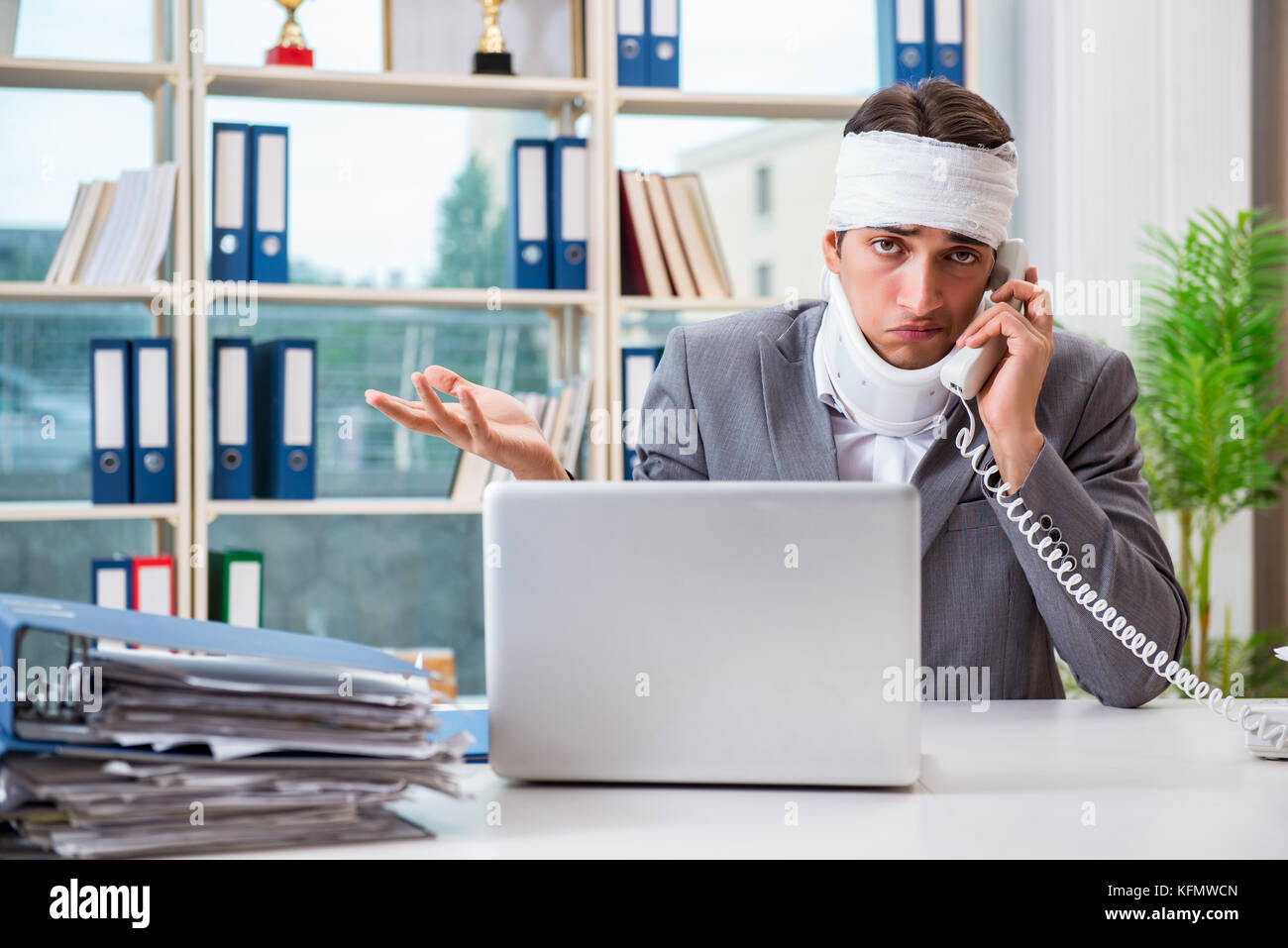 Injured businessman working in the office Stock Photo - Alamy