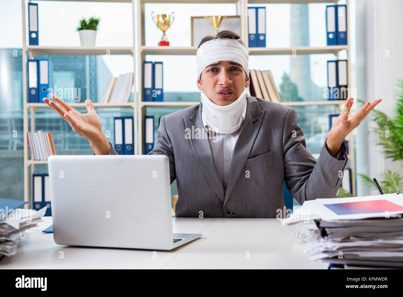 Injured businessman working in the office Stock Photo - Alamy