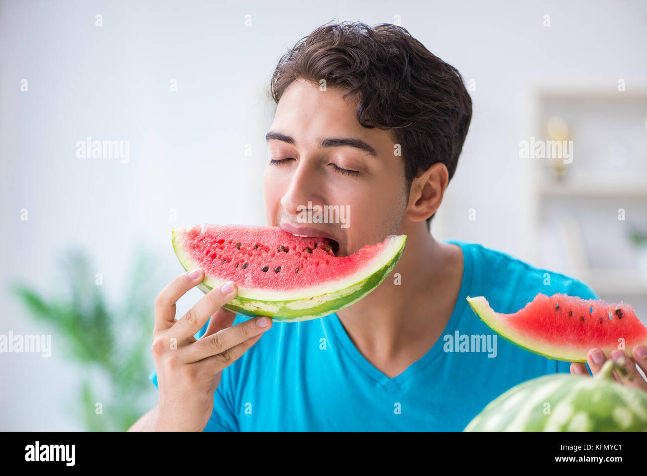 Man eating watermelon at home Stock Photo - Alamy