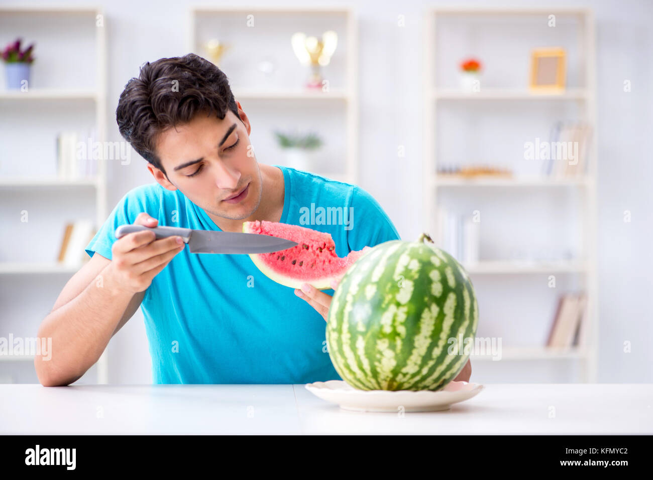 Man eating watermelon at home Stock Photo - Alamy
