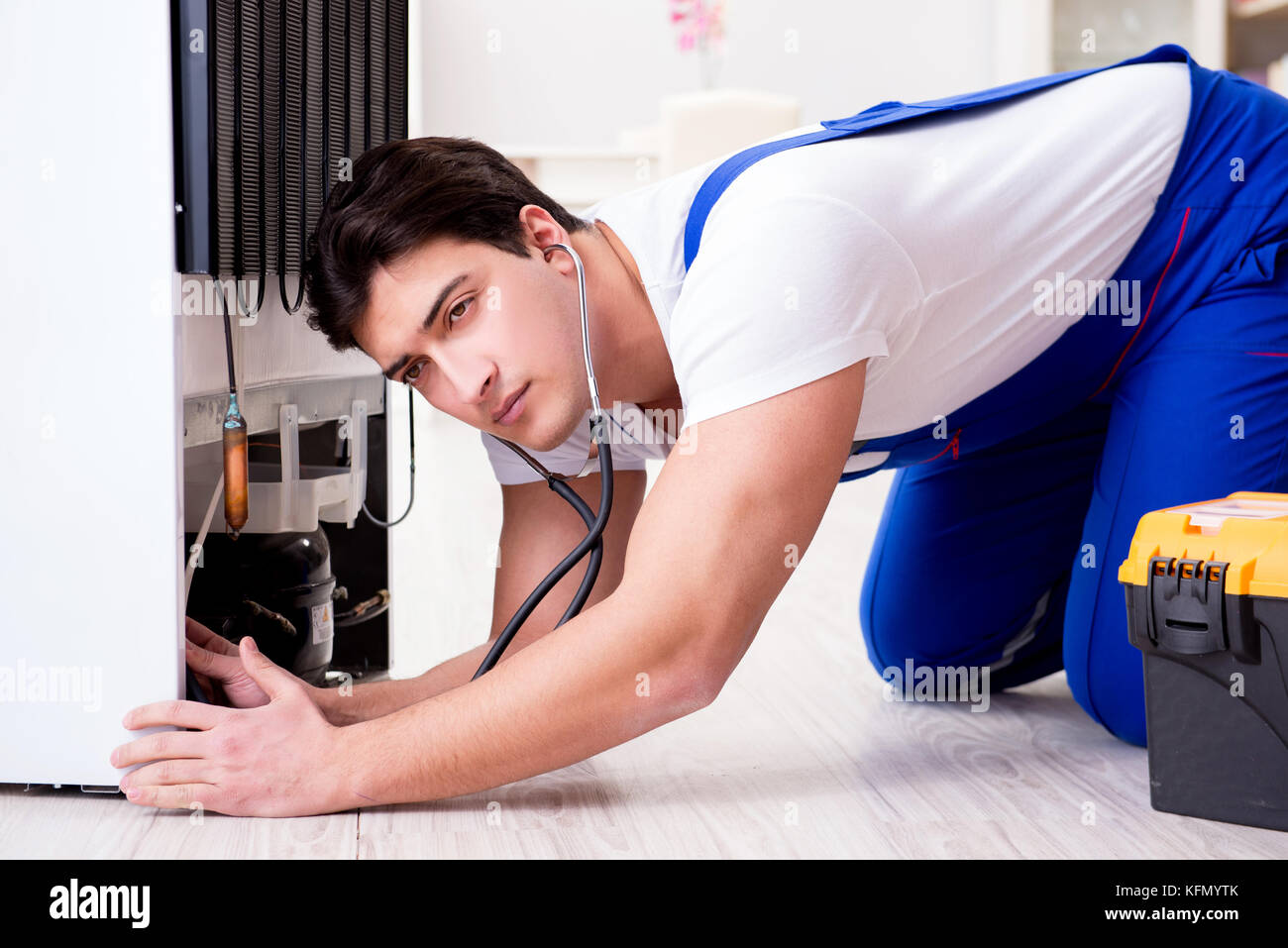 Repairman contractor repairing fridge in DIY concept Stock Photo - Alamy