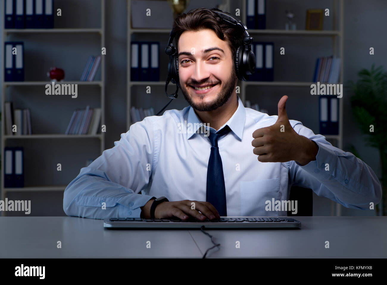 Young man in call center concept working late overtime in office Stock ...