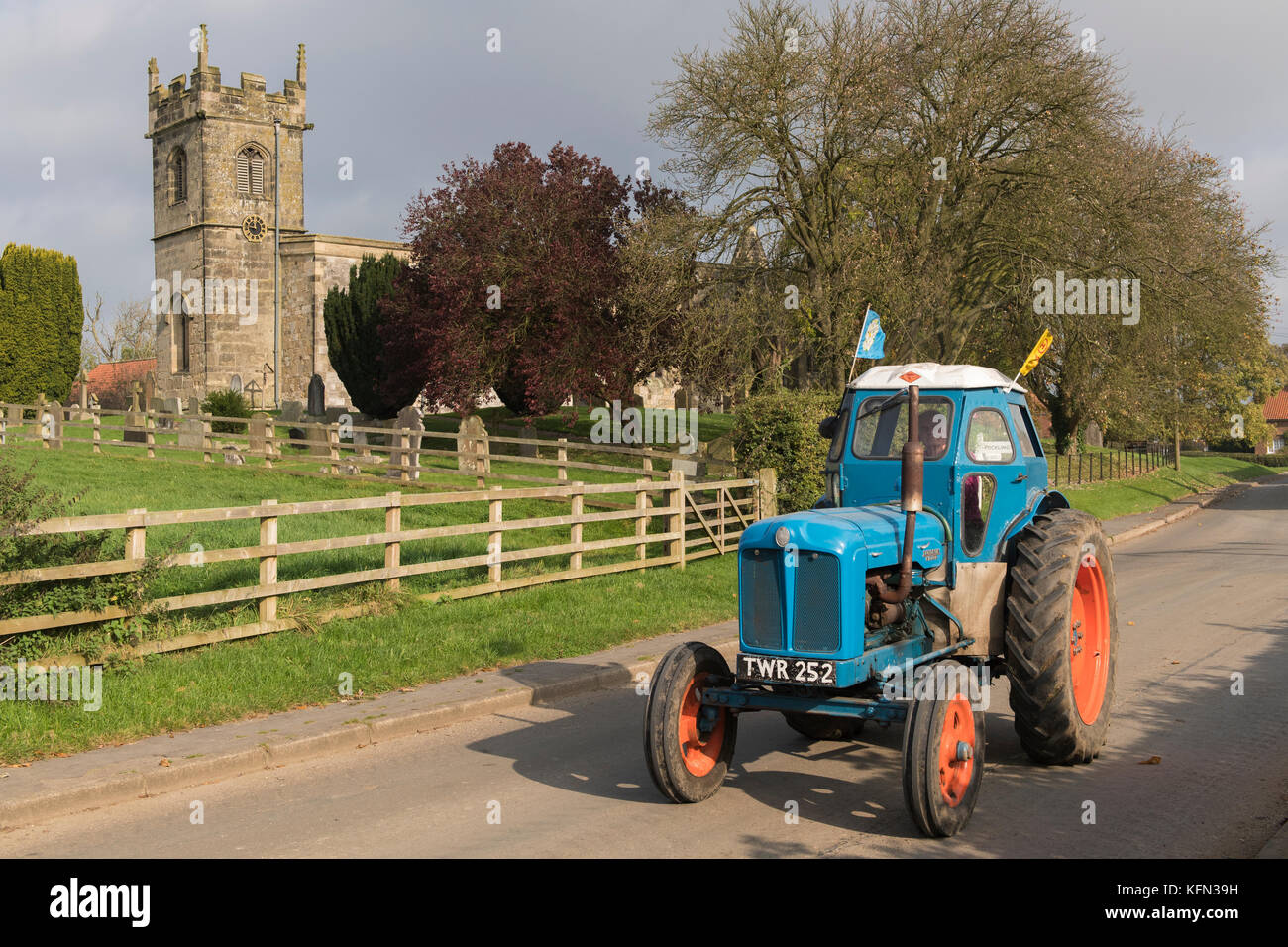 Man driving old blue vintage tractor through village of Bugthorpe on ...