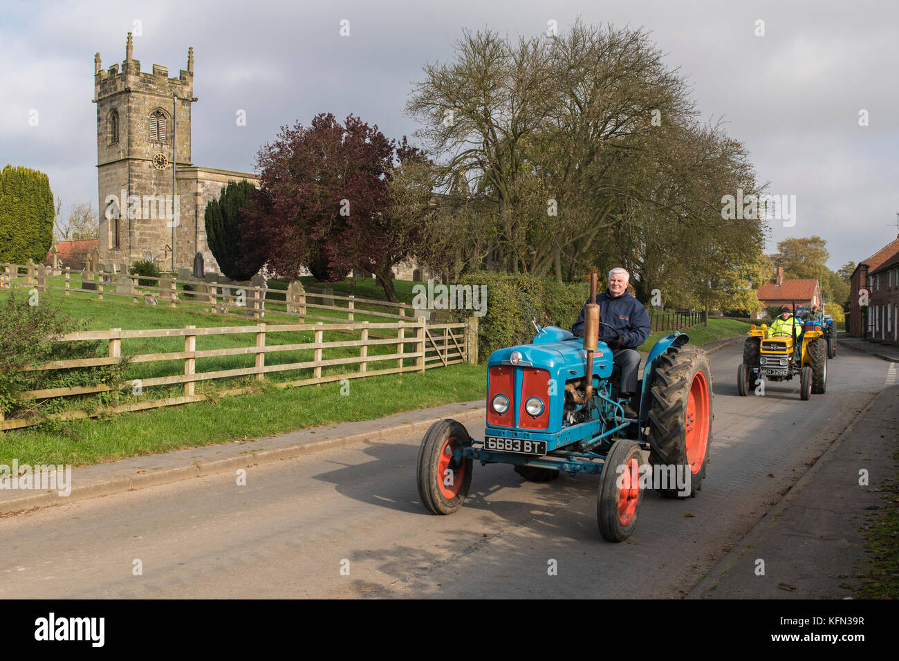 Man driving old blue vintage tractor through village of Bugthorpe on ...