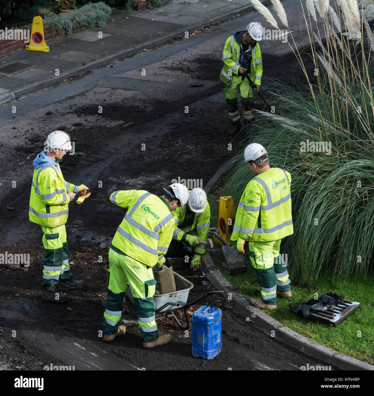A Conway roadworks crew laying down new asphalt on a road in London ...