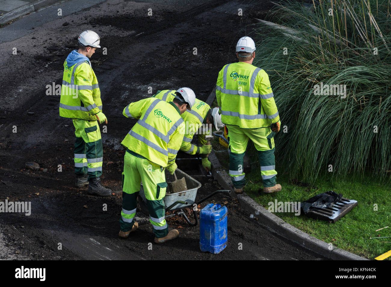 A Conway roadworks crew laying down new asphalt on a road in London ...