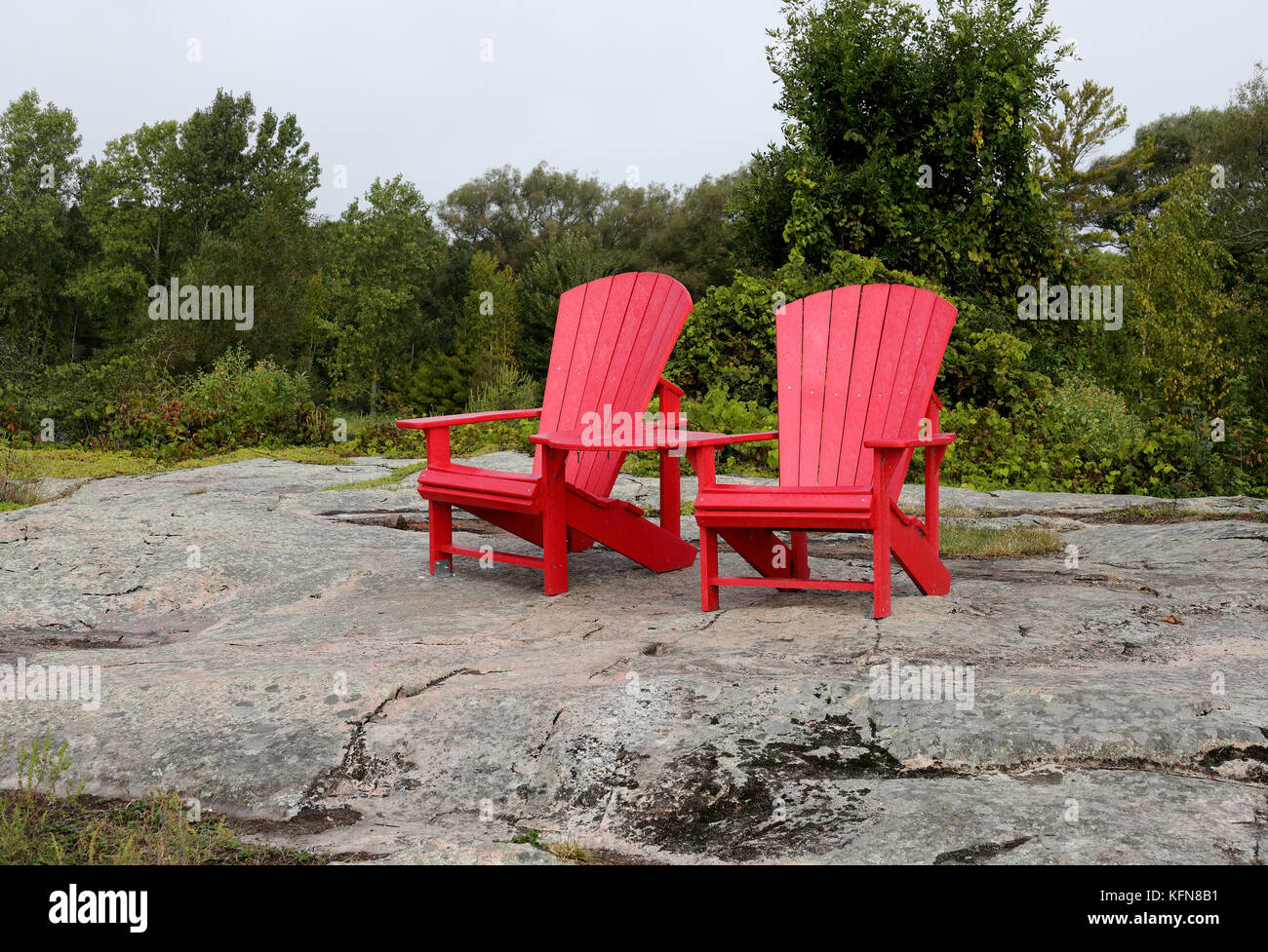 Two red chairs on a granite hill in a park Stock Photo - Alamy