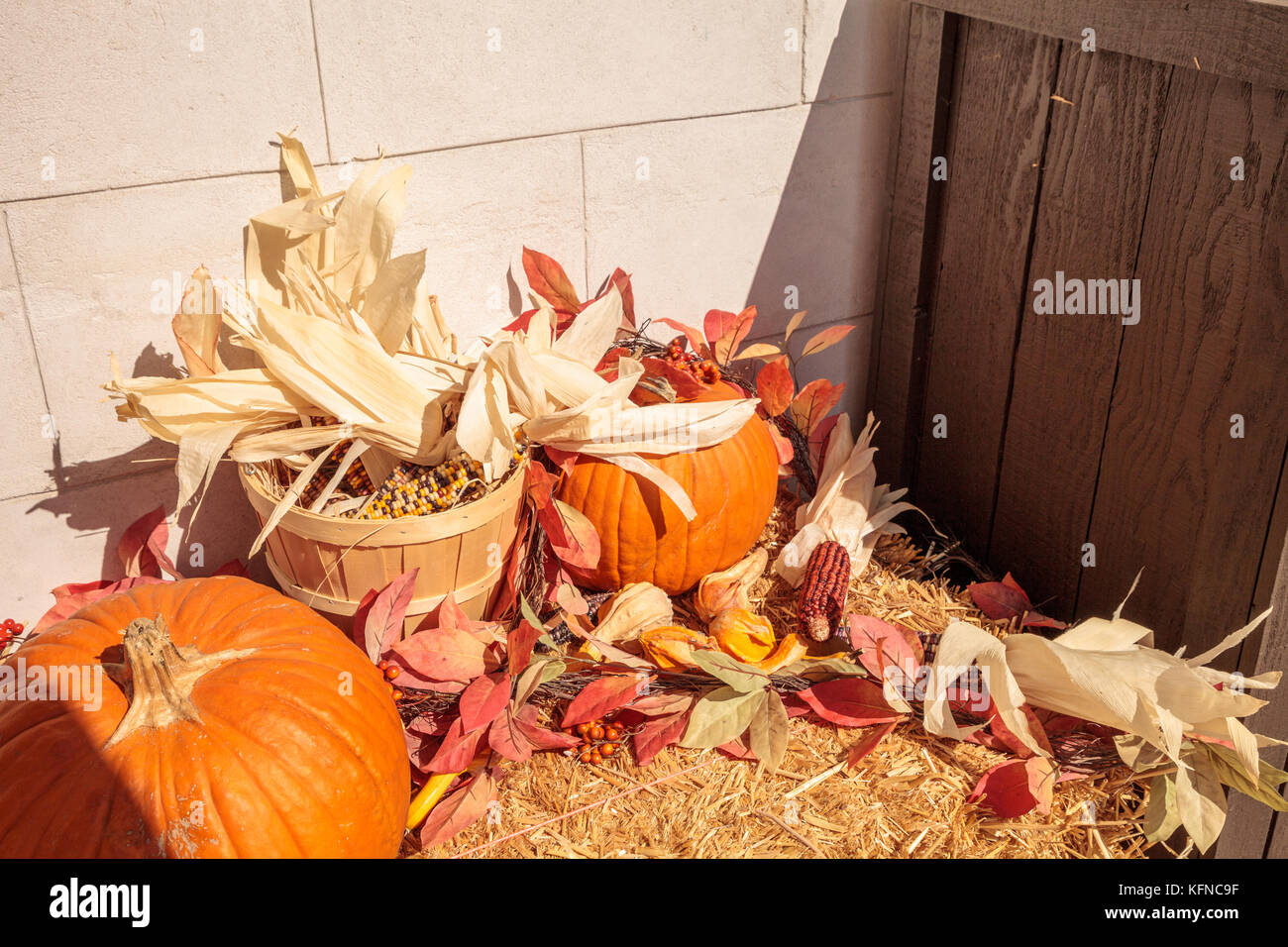 Halloween display of fall leaves and pumpkin on bails of hay to ...